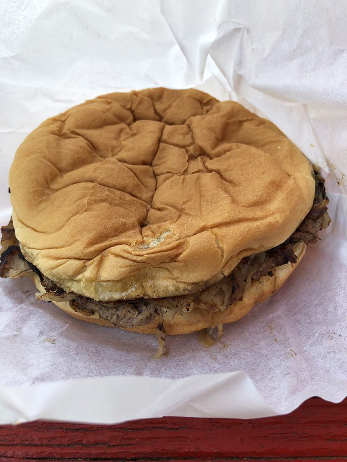 The humble onion burger in its natural habitat&mdash;wrapped in paper, ready to be devoured, with those crispy onion edges that burger dreams are made of.