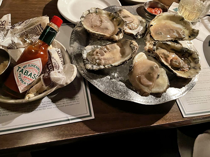 Fresh oysters on ice with a bottle of Tabasco standing guard. The ocean's perfect appetizer awaits your squeeze of lemon.
