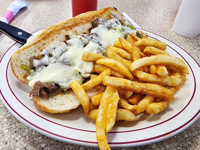 A proper Philly cheesesteak that would make Rocky himself climb those steps in triumph, accompanied by fries that deserve their own boxing championship.
