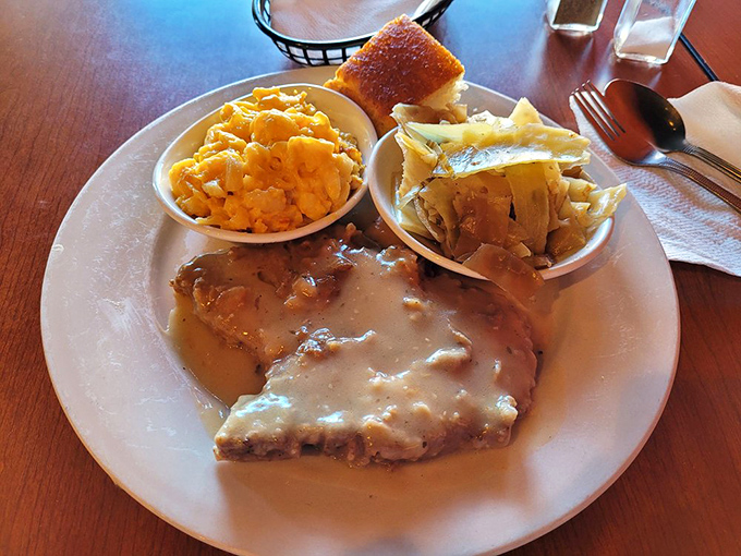 Gravy-smothered pork chop with mac and cheese that's clearly been taking its relationship with cheddar very seriously.