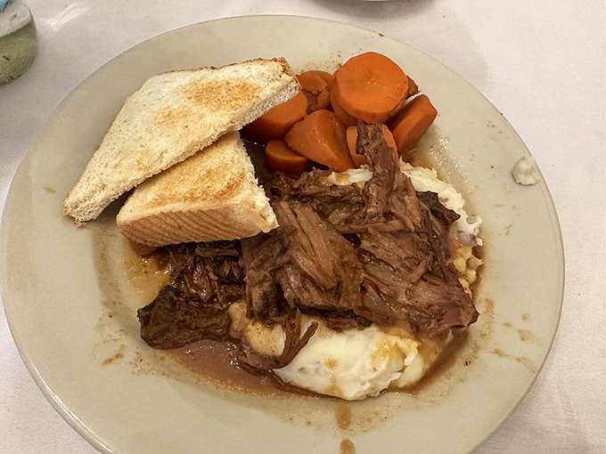 Fork-tender pot roast melting over homemade mashed potatoes with carrots that taste like they were pulled from Missouri soil this morning.