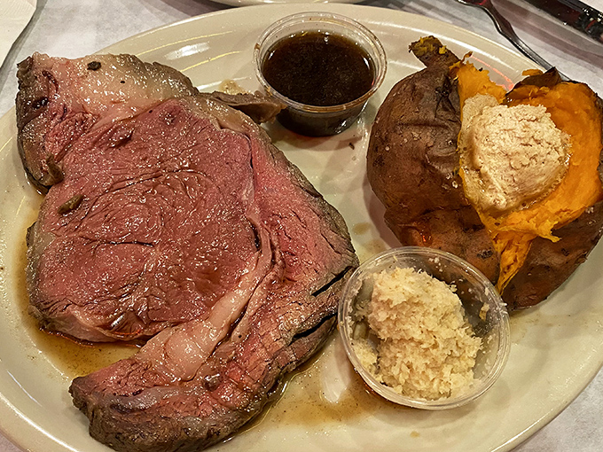 The prime rib glistens with its own juices, whispering promises of beefy perfection. That loaded sweet potato? Just showing off at this point.