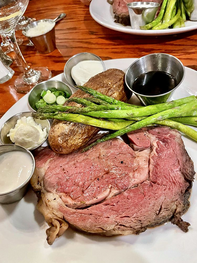 The prime rib arrives like royalty &ndash; a thick, rosy slab escorted by asparagus soldiers and a potato companion worthy of its magnificence.