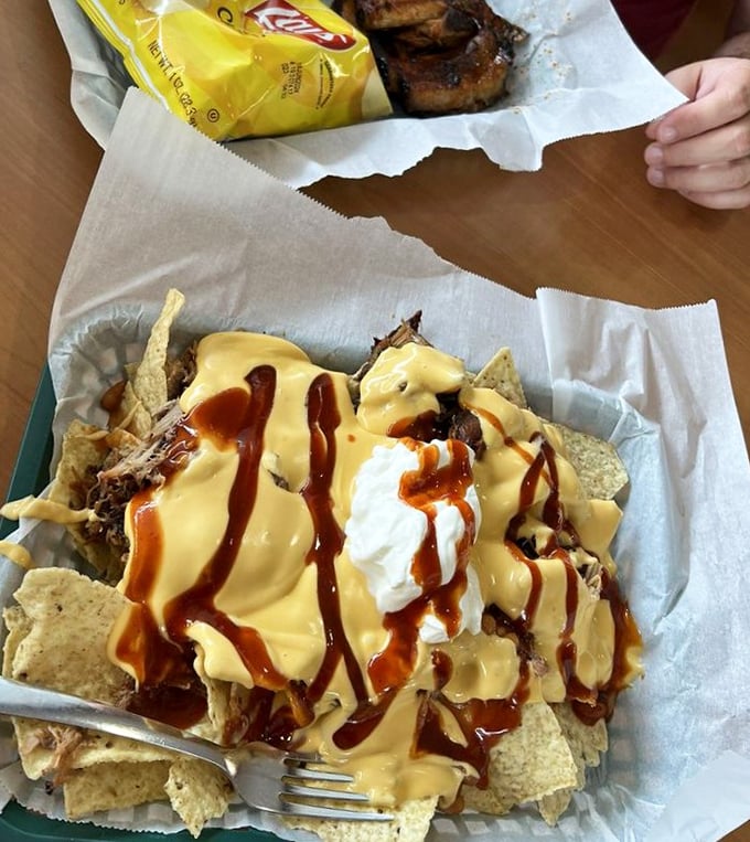 Pulled pork nachos: where tortilla chips fulfill their highest calling as vehicles for meat, cheese, and sauce. Forks are purely optional.