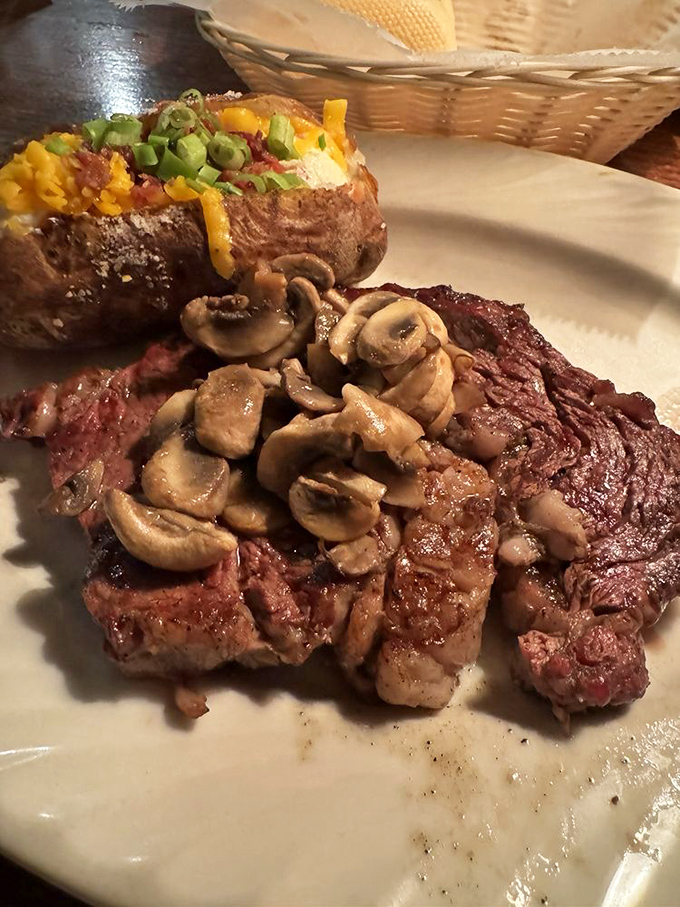 A steak that doesn't play second fiddle to seafood &ndash; ribeye crowned with mushrooms beside a loaded potato that's a meal itself.