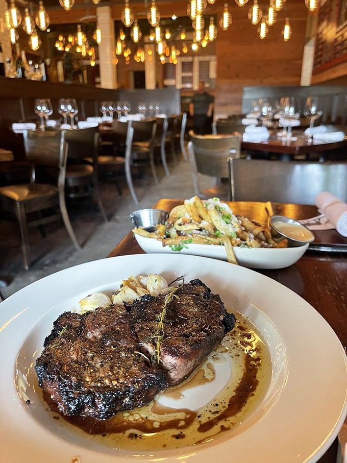 When steak meets aromatherapy: a perfectly cooked ribeye shares the spotlight with roasted garlic cloves&mdash;nature's candy after a kiss from the flame.