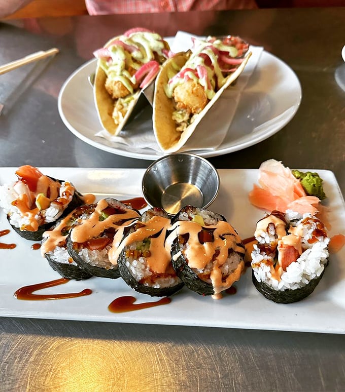 Sushi rolls and fish tacos sharing a plate like old friends at a reunion. The sauce drizzle isn't just condiment&mdash;it's liquid personality.