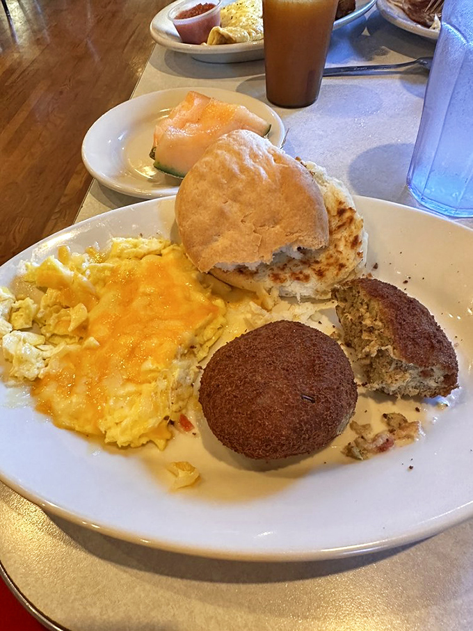 The breakfast trinity: perfectly scrambled eggs, a biscuit that could float away if not for gravity, and a salmon cake that tastes like the ocean's best offering.