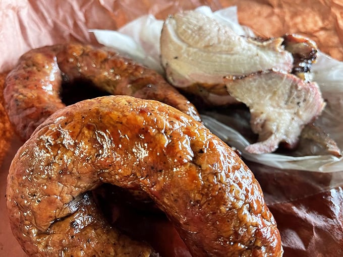 That sausage casing snaps like the world's most delicious firework, releasing a juicy explosion that makes you momentarily forget your table manners.