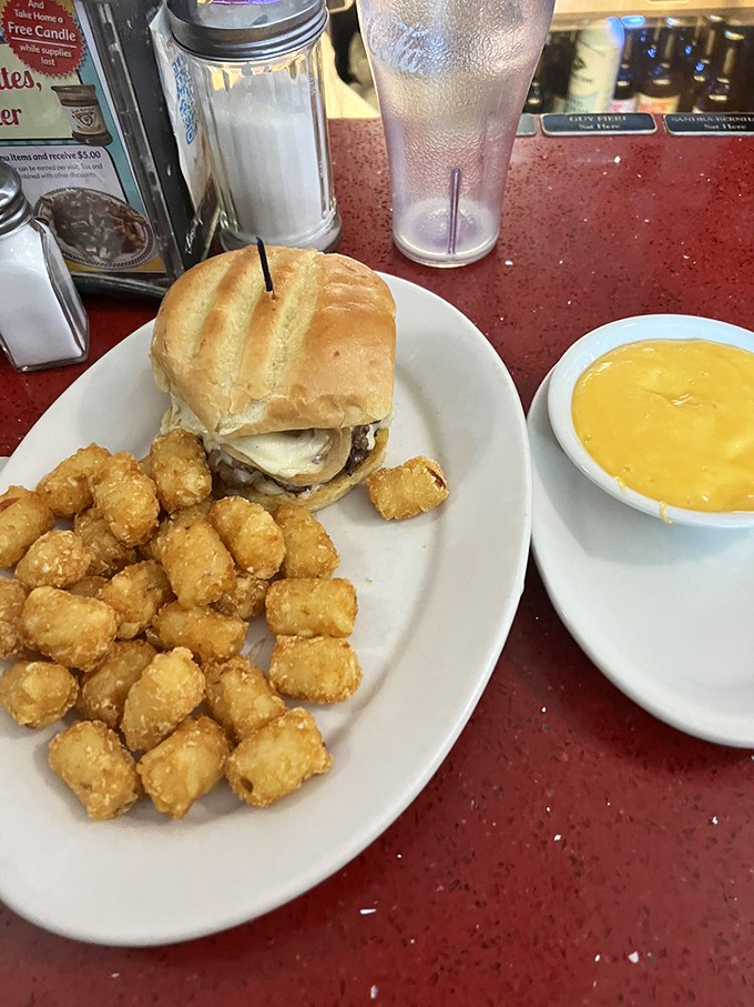 This isn't just a burger&mdash;it's architecture. The tater tots standing guard nearby know they're in the presence of greatness.