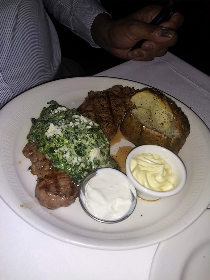 Steak topped with creamed spinach alongside a loaded baked potato&mdash;the holy trinity of steakhouse perfection that would make Frank Sinatra nod in approval.