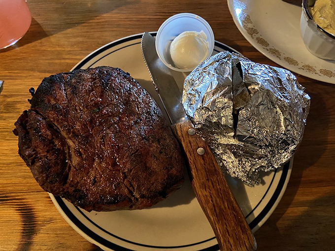 That satisfying moment when your plate arrives with a steak so substantial it makes the massive baked potato look like a mere side note.