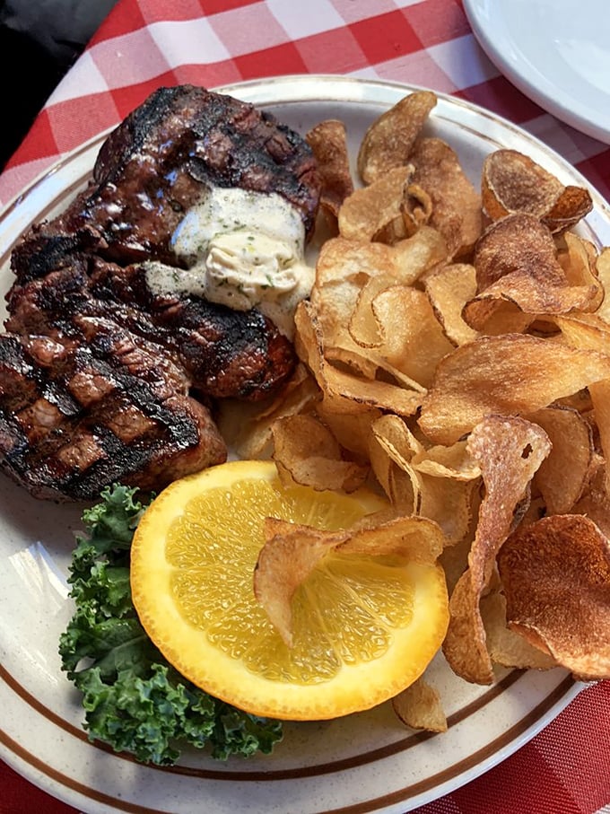 Grill marks like tiger stripes across a juicy steak, accompanied by house-made potato chips that shatter with satisfying crispness between your teeth.
