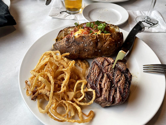 Steak, crispy onion straws, and a loaded potato&mdash;the holy trinity of steakhouse perfection. Diet culture weeps in the corner.