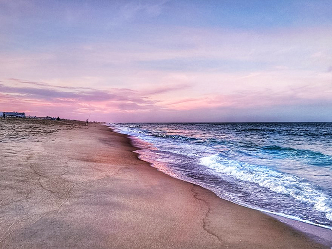 Sunset paints the shoreline in watercolor hues that would make Bob Ross weep with joy &ndash; just a happy little beach moment.