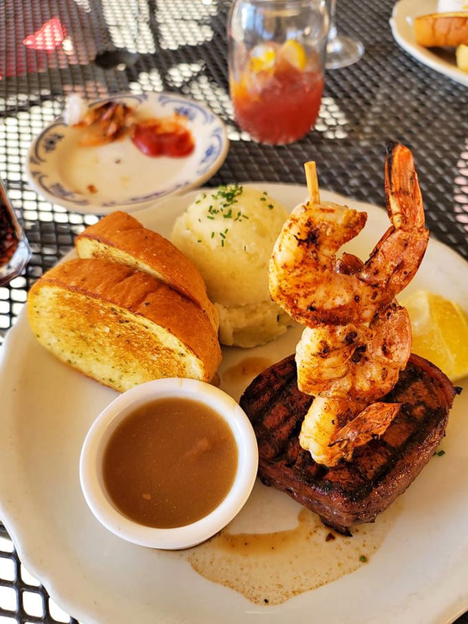 Garlic bread, mashed potatoes, and steak with shrimp&mdash;a plate that says "diet starts tomorrow" in the most convincing way possible.