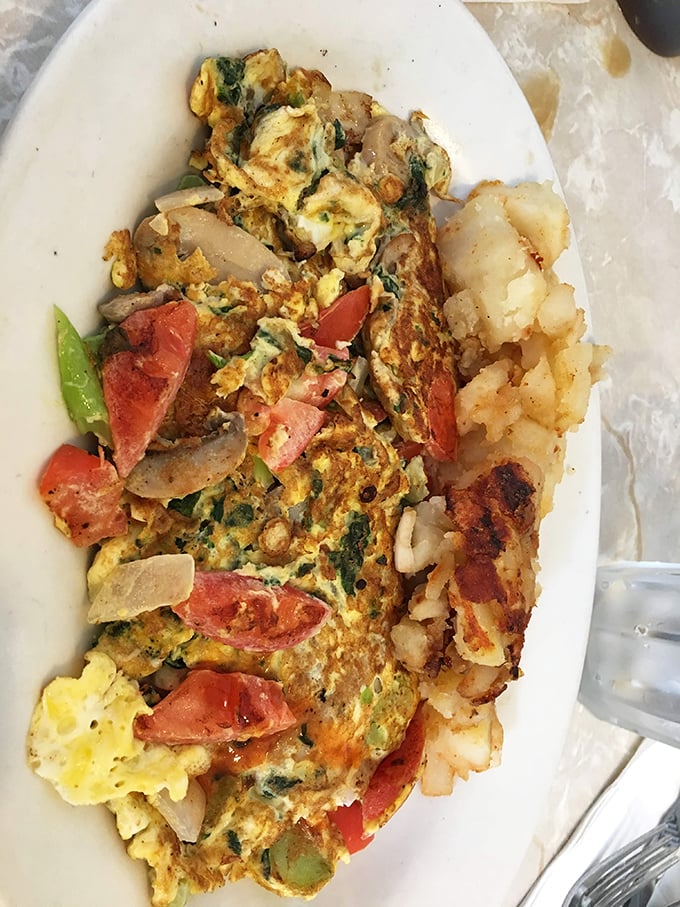 A vegetable omelet that doesn't apologize for being simple&mdash;fresh tomatoes, onions and greens embraced by eggs that clearly met their pan at precisely the right temperature.