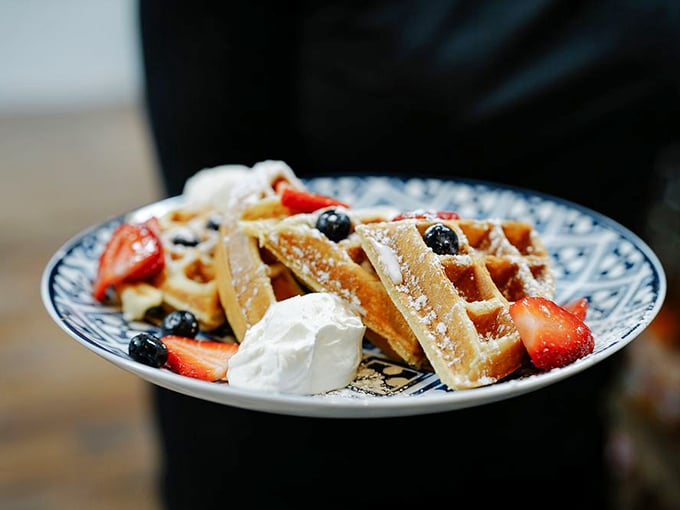 Waffles aren't just breakfast here—they're an art form. With berries, whipped cream, and powdered sugar, they're dressed better than I am most days.