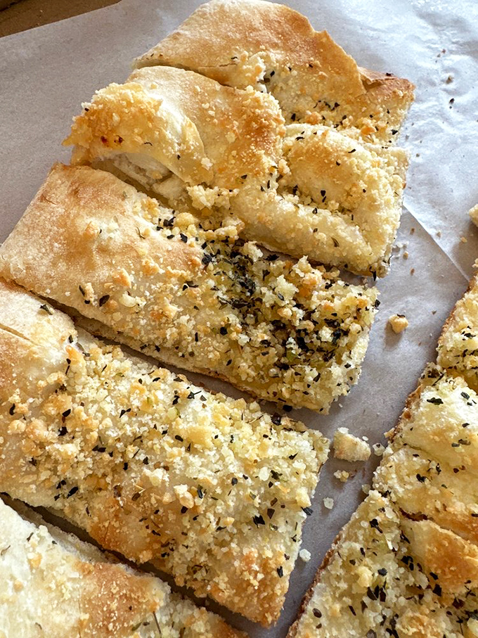 Garlic bread reimagined as an art form. These herb-flecked, golden-brown wedges are the opening act that threatens to steal the whole show.