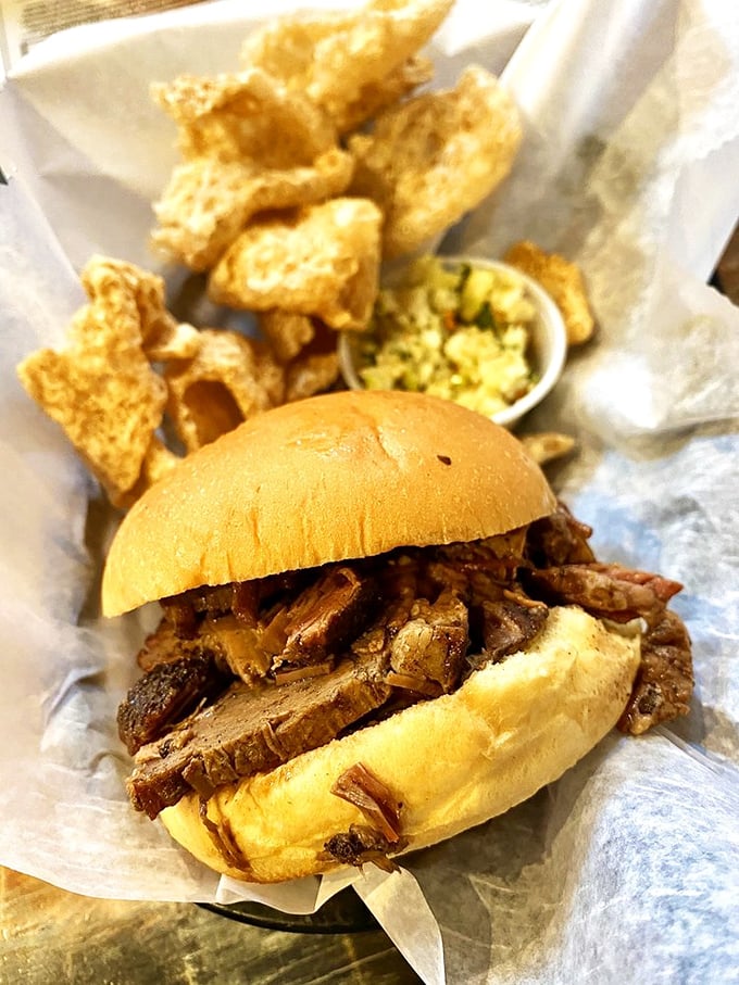 A brisket sandwich stands proudly alongside crispy pork skins—proof that simple pleasures remain undefeated in the culinary Olympics.