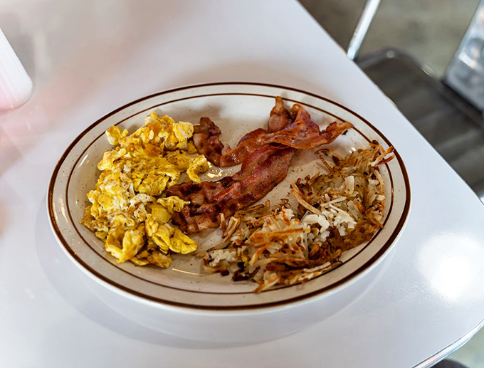 The holy trinity of breakfast: perfectly scrambled eggs, crispy bacon, and hash browns that somehow manage to be both fluffy and crispy.