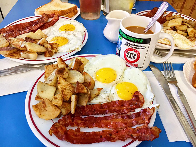 The breakfast trinity: eggs sunny-side up, bacon crisped to perfection, and home fries that could make a potato farmer weep with pride.