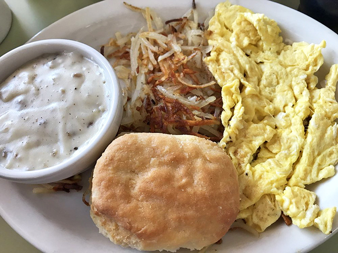 Breakfast nirvana: fluffy scrambled eggs, crispy hash browns, and a biscuit that could make your grandmother question her recipe.
