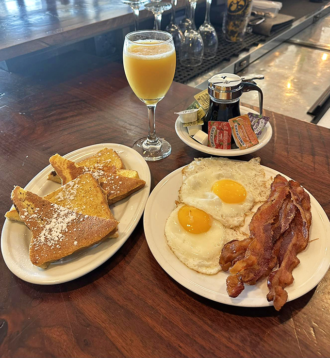 The breakfast trinity: golden French toast, sunny-side-up eggs, and bacon cooked to that magical place between chewy and crisp. Plus mimosa—because why not?