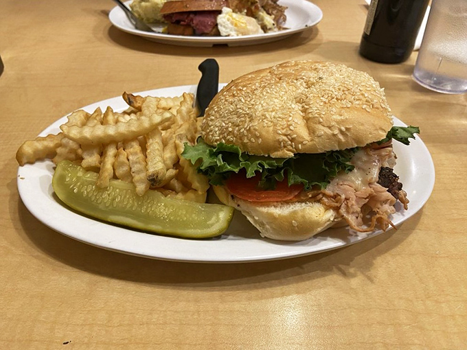 A sesame-studded bun cradles fresh turkey and crisp veggies, while those crinkle-cut fries stand at attention like delicious golden soldiers.