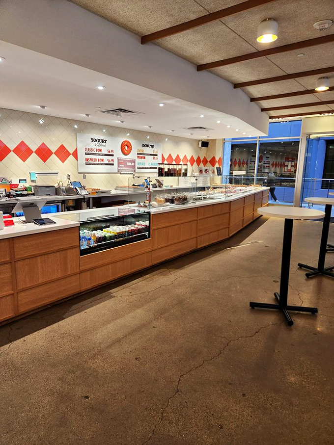 Behind this counter, donut magic happens daily. The curved wood and diamond pattern tiles create a stage for the real stars of the show.