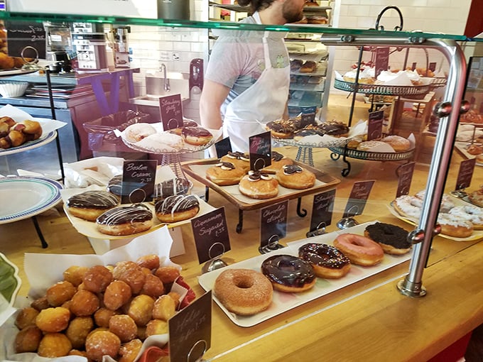 Behind this glass lies a kingdom of fried dough royalty. The donut holes, like courtiers, surround their more elaborate counterparts.