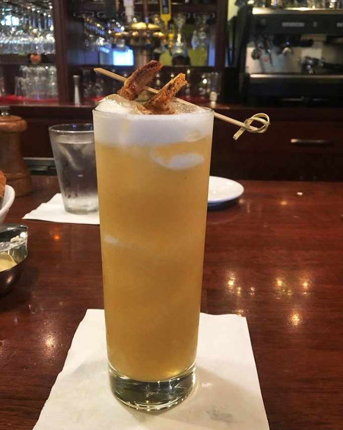 A cocktail that looks like liquid sunshine, complete with a garnish that says, "Yes, we're serious about drinks too."