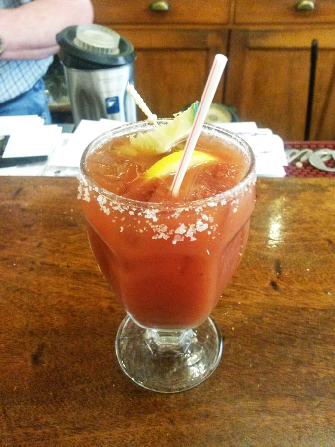 A proper Bloody Mary with its salt-rimmed glass and garden of garnishes—proving that sometimes vegetables are best served swimming in vodka.