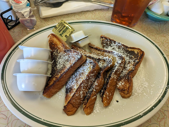 French toast that's achieved the golden ratio of crispy exterior and custardy interior. The powdered sugar is just showing off at this point.