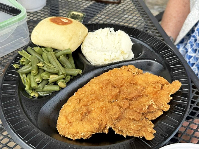 The chicken dinner arrives like a golden comfort food postcard from the heartland—crispy coating, fluffy potatoes, and green beans your grandma would approve of.