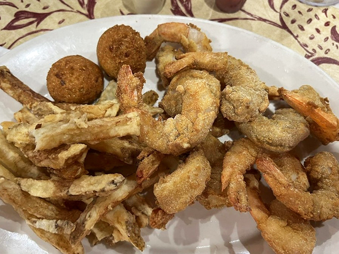 Fried shrimp and hush puppies arranged like golden treasures on a white plate. Seafood this fresh makes you wonder why anyone lives far from water.