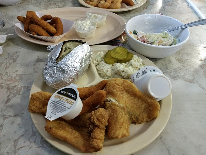 A complete Twin Tops feast: perfectly fried fish, creamy coleslaw, and a baked potato wrapped in foil like the gift it truly is.