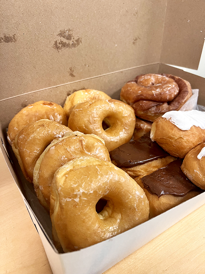 Golden-hued glazed donuts nestled together like old friends, their sugar coating glistening with promises they absolutely intend to keep.