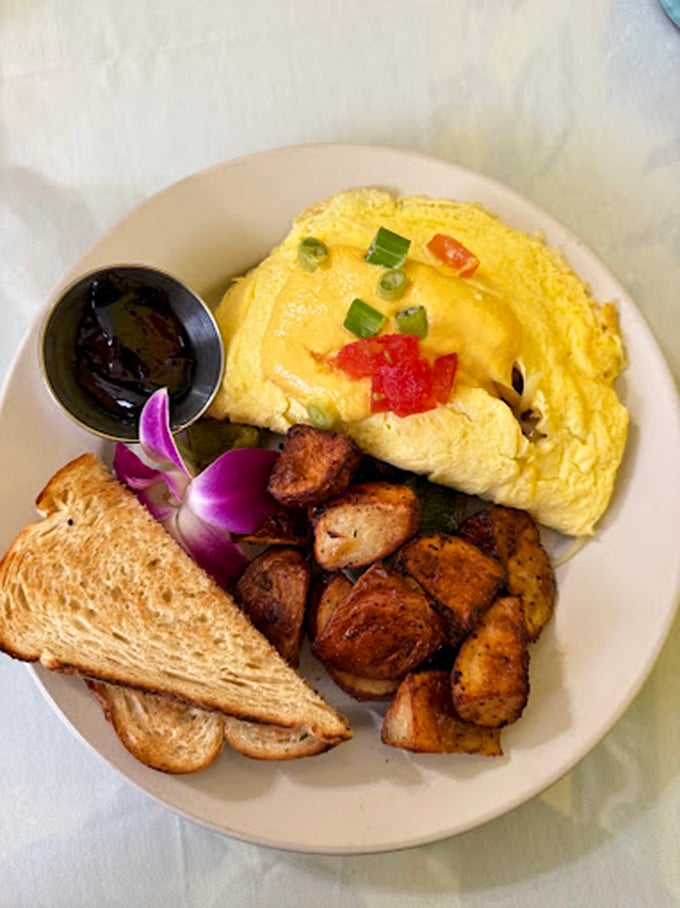 The omelette arrives fluffy and vibrant, topped with fresh vegetables that weren't just an afterthought but invited guests to the party.