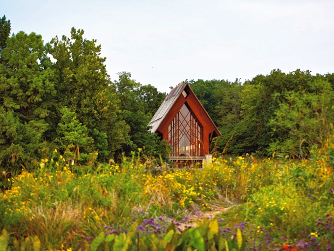 A storybook chapel emerges from wildflower meadows like something from a Hayao Miyazaki film—magical, unexpected, and utterly serene.