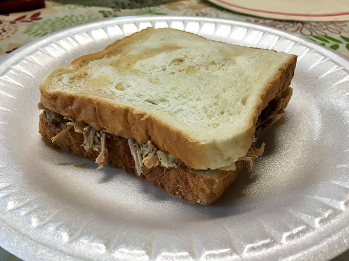 The classic Arkansas sandwich in all its glory. White bread embracing smoky pulled pork and tangy slaw—a harmonious trio that sings of Southern comfort.
