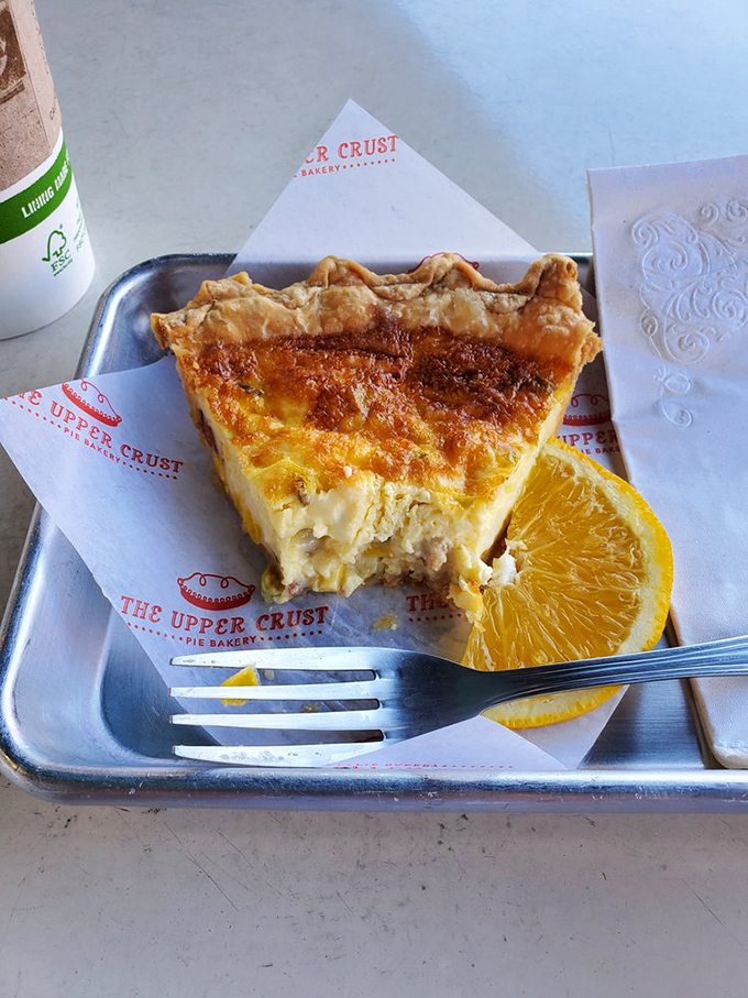 Quiche done right is poetry on a checkered tablecloth. This slice, with its perfect custard and flaky crust, makes breakfast feel like an occasion.