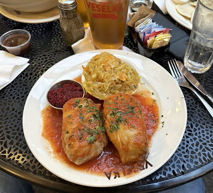 Stuffed cabbage that whispers comfort with every bite, bathed in tangy tomato sauce and served with traditional sauerkraut that's nothing like the stuff from jars.