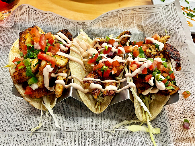 These fish tacos aren't just a meal, they're a fiesta on newspaper. Crispy fish, fresh slaw, and zigzags of sauce create a harmony that would make even coastal taco stands envious.