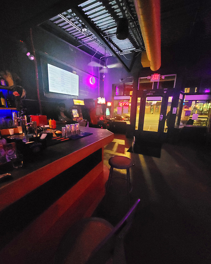 The bar's moody lighting and circular pendant lamps create an ambiance that's equal parts speakeasy and 80s basement – in the best possible way.