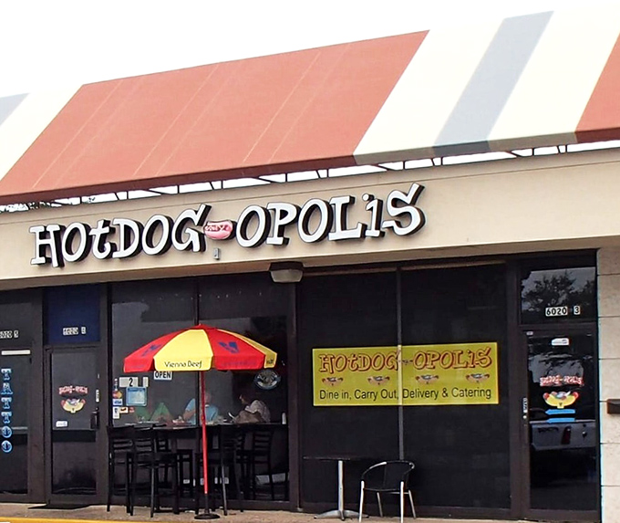 Hotdogopolis stands like a temple to tubular meat worship, its red and yellow umbrellas beckoning hot dog pilgrims from across the state.