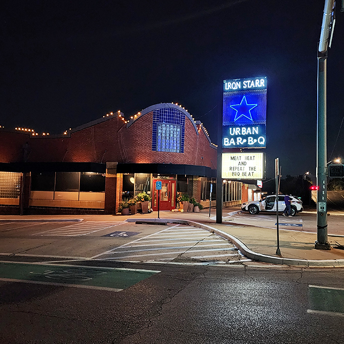 Iron Star's distinctive curved architecture and blue neon glow&mdash;where barbecue tradition meets big city sophistication.