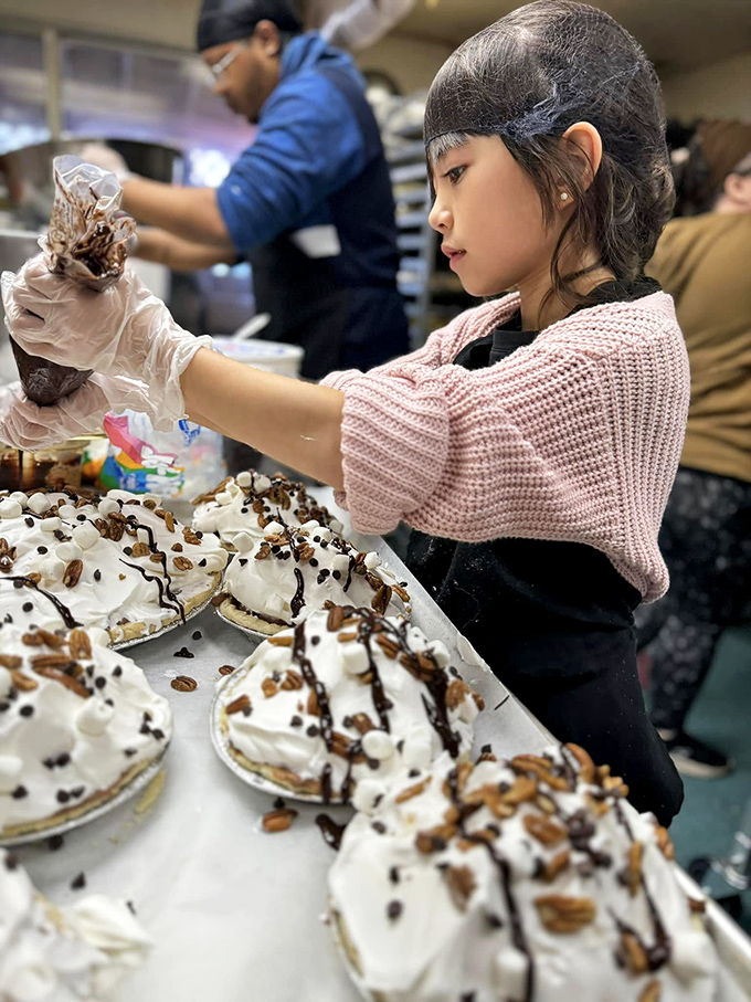 Behind the scenes where the magic happens—cream pies being lovingly decorated by hands that understand the importance of dessert.