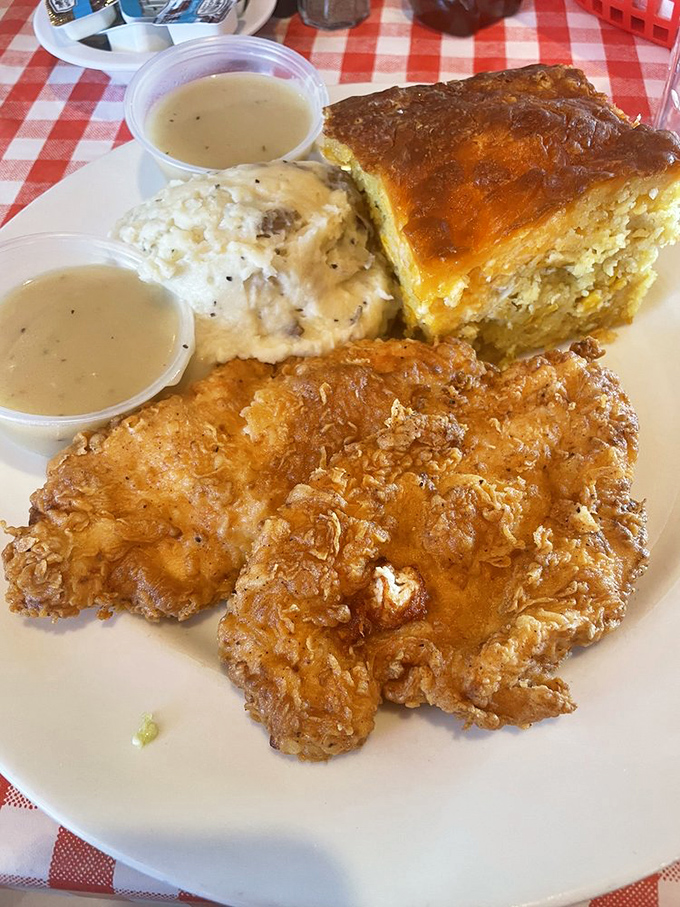 The holy trinity of comfort: golden-fried chicken, buttery mashed potatoes, and what appears to be their famous corn pudding. Two cups of gravy because one is never enough.
