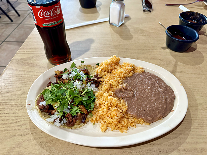 The holy trinity of Mexican comfort: perfectly seasoned rice, velvety refried beans, and tacos that transport you straight to a Mexico City street corner.